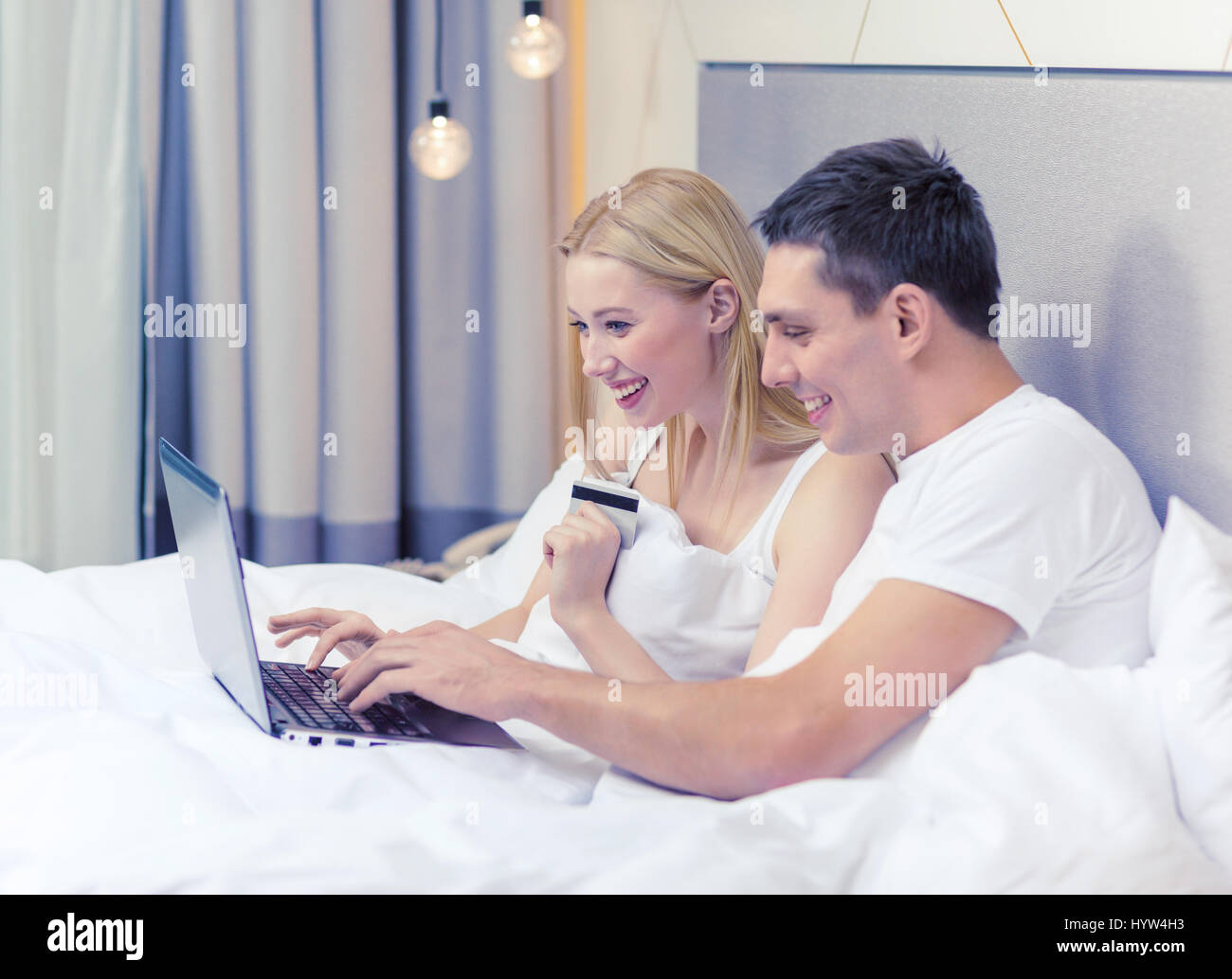 couple in bed with laptop computer and credit card Stock Photo - Alamy