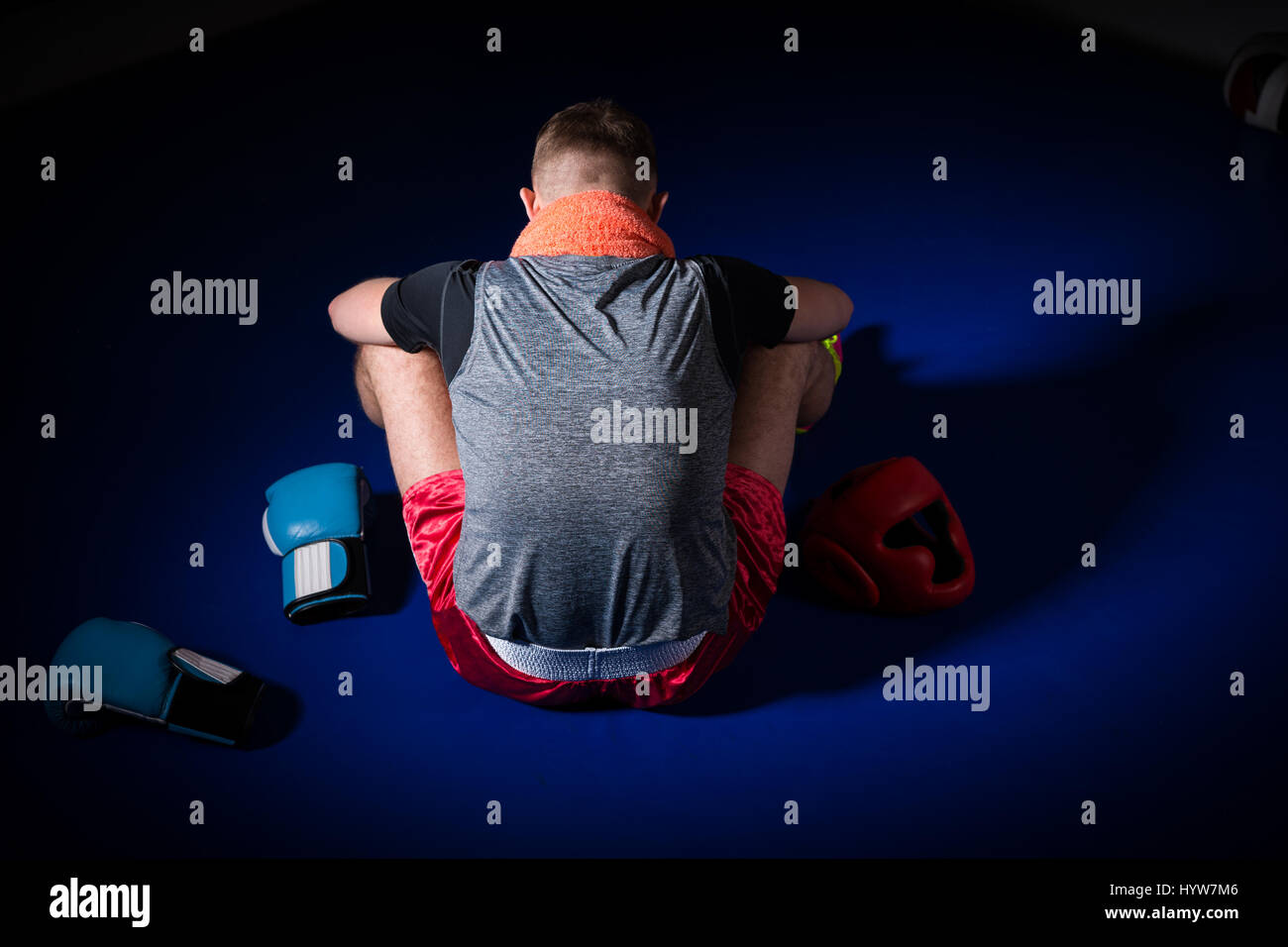 Young athletic male boxer with a towel around his neck sitting ...
