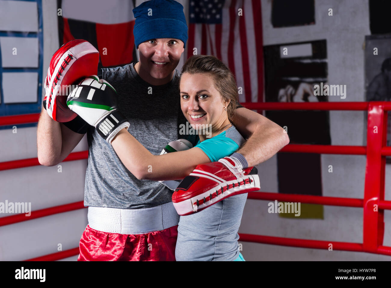Athletic female hugs her coach in regular boxing ring in a gym Stock ...