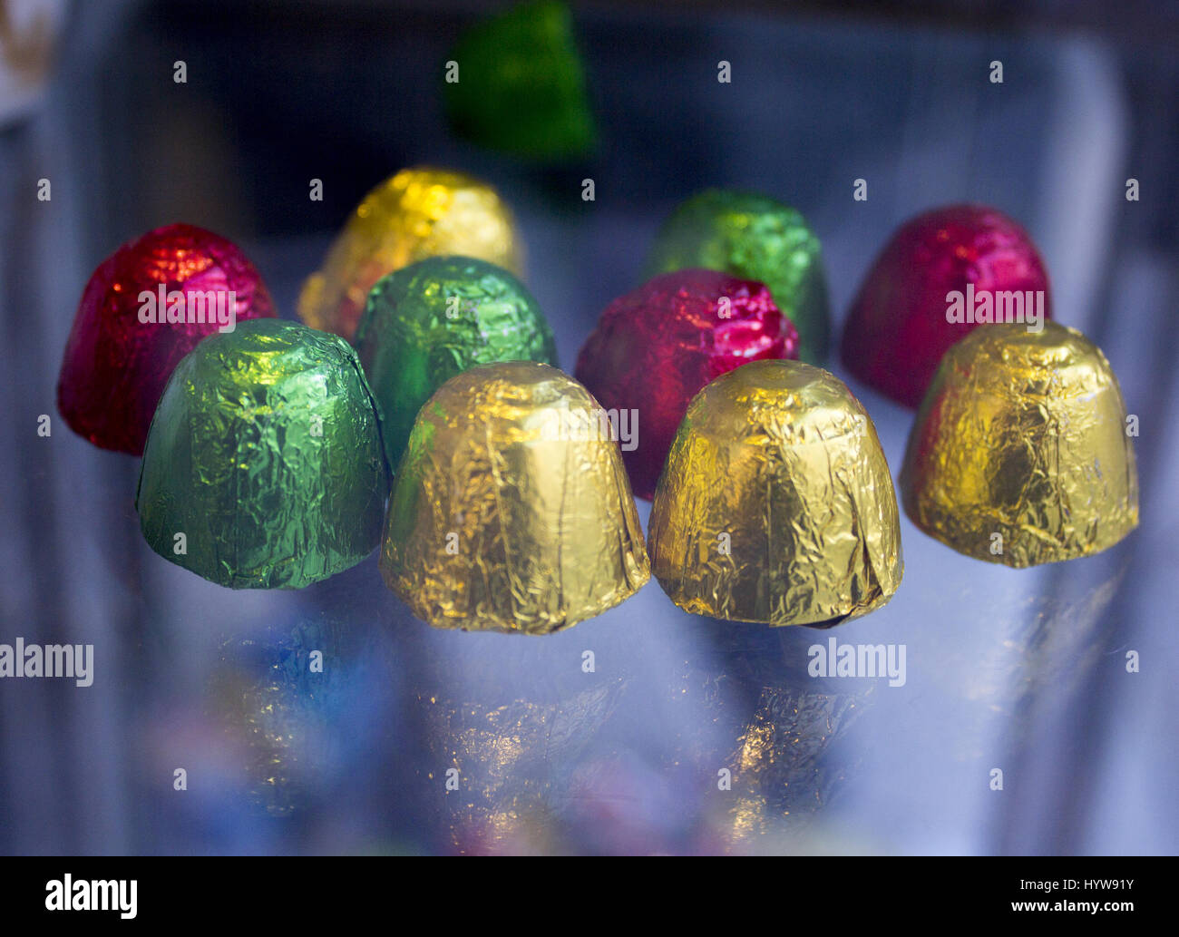 Small chocolates wrapped in metallic paper Stock Photo - Alamy