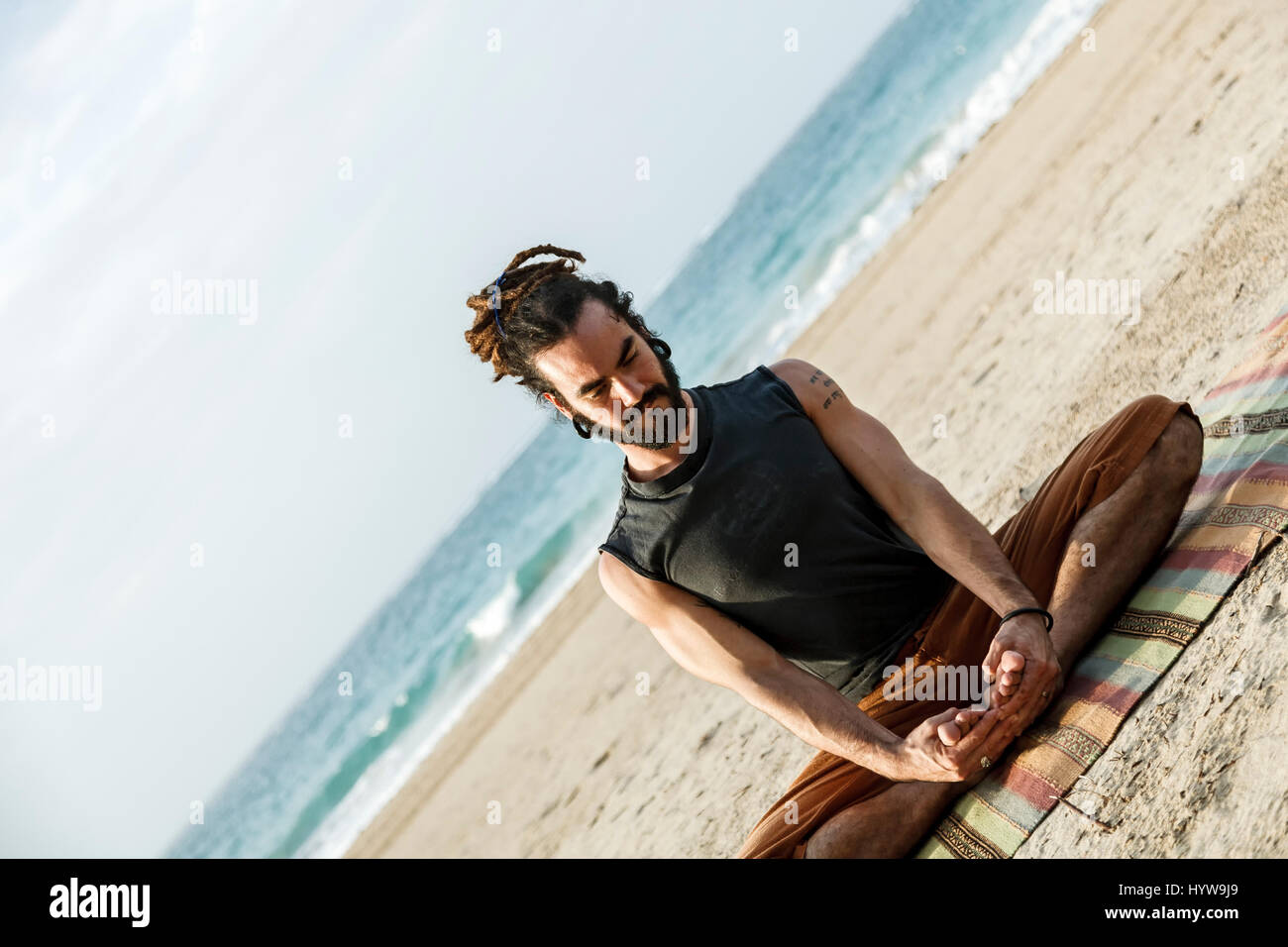 Man practicing yoga on beach, Ocean Park, Puerto Rico Stock Photo - Alamy
