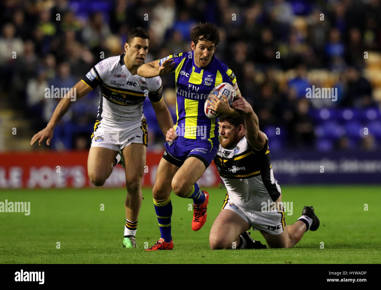 Warrington Wolves' Stefan Ratchford (centre) is tackled by Leeds Rhinos ...