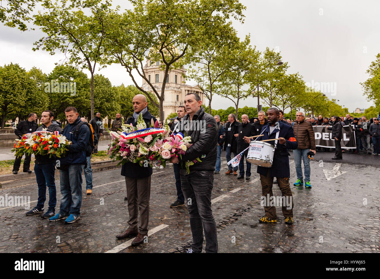 Paris, France. 26th April, 2017. Police officers hold funeral flowers ...