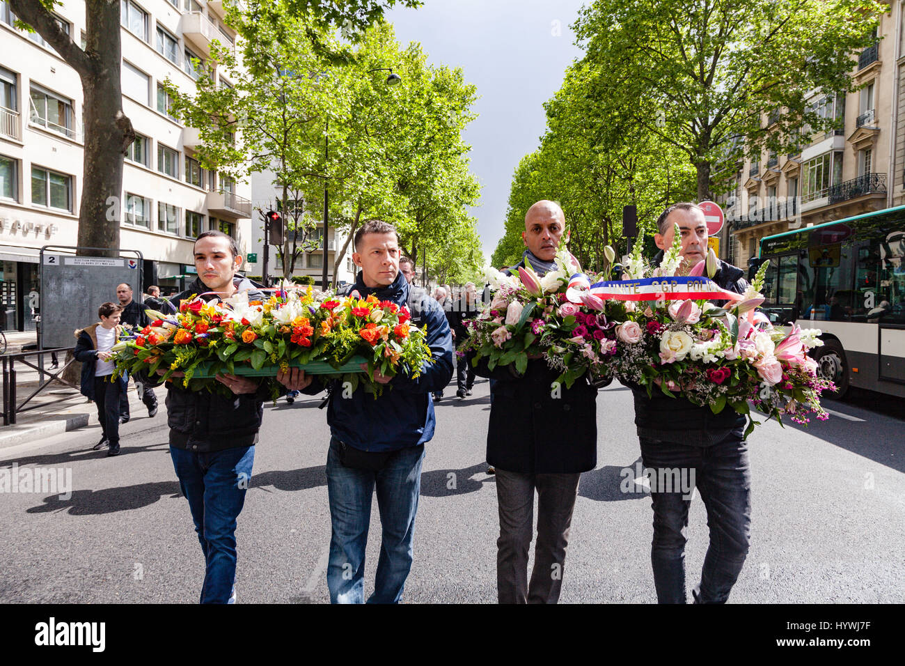 Paris, France. 26th April, 2017. Police officers hold funeral flowers ...