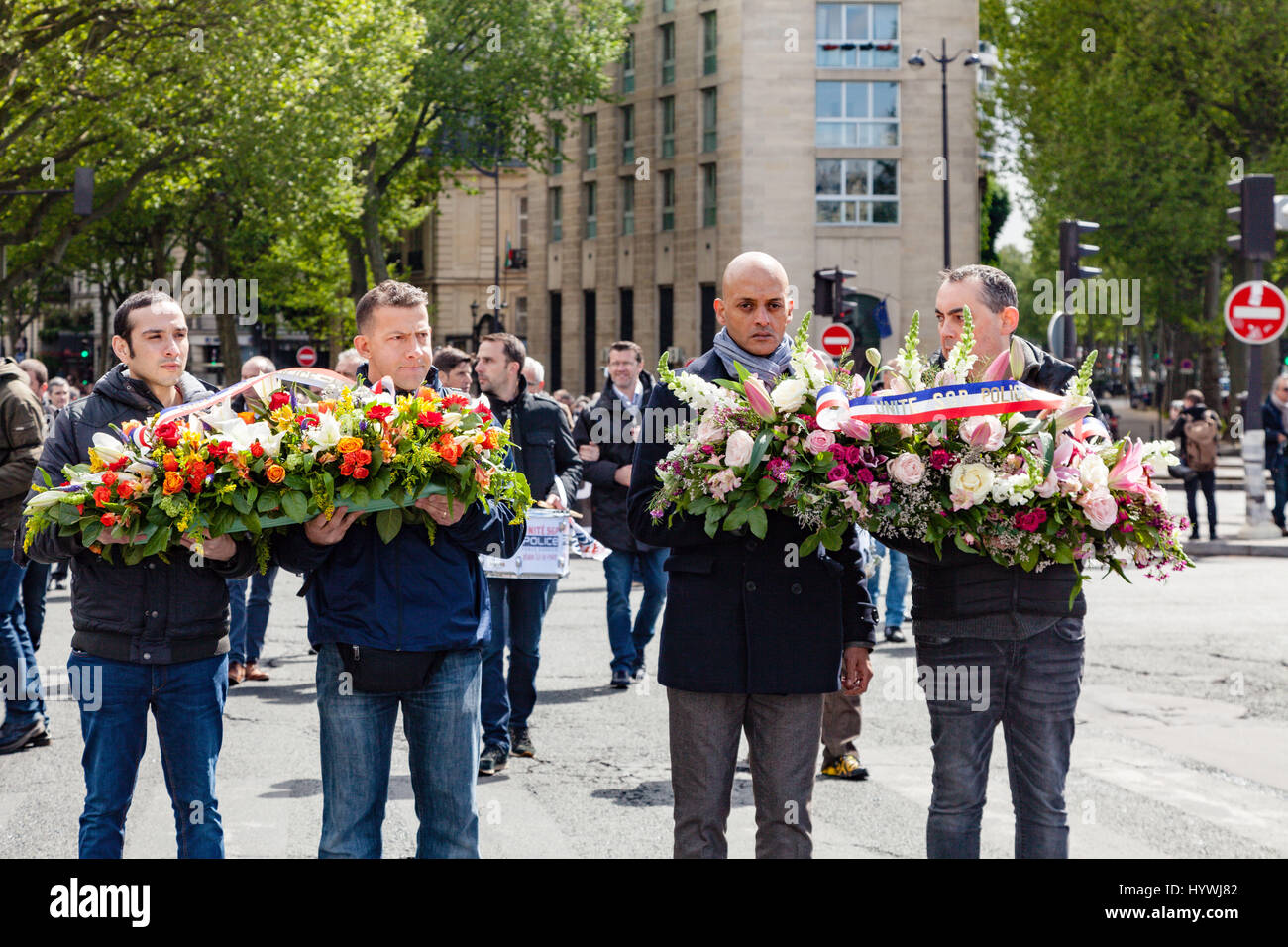 Paris, France. 26th April, 2017. Police officers hold funeral flowers ...