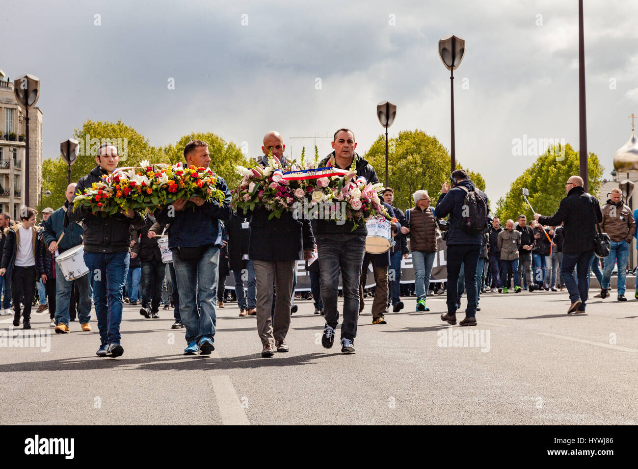 Paris, France. 26th April, 2017. Police officers hold funeral flowers ...