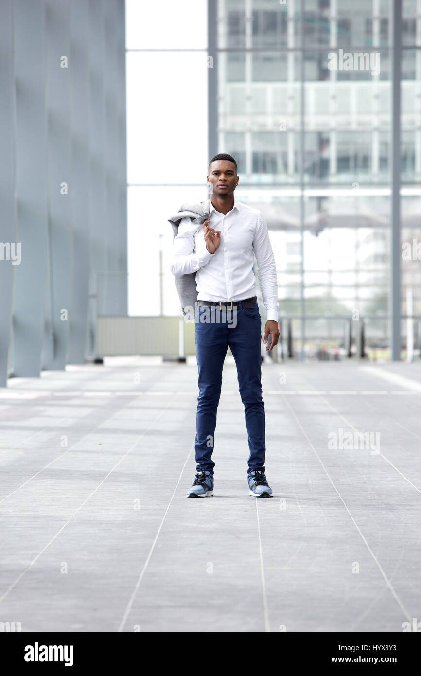 Full length portrait of a trendy young man standing in building alone ...