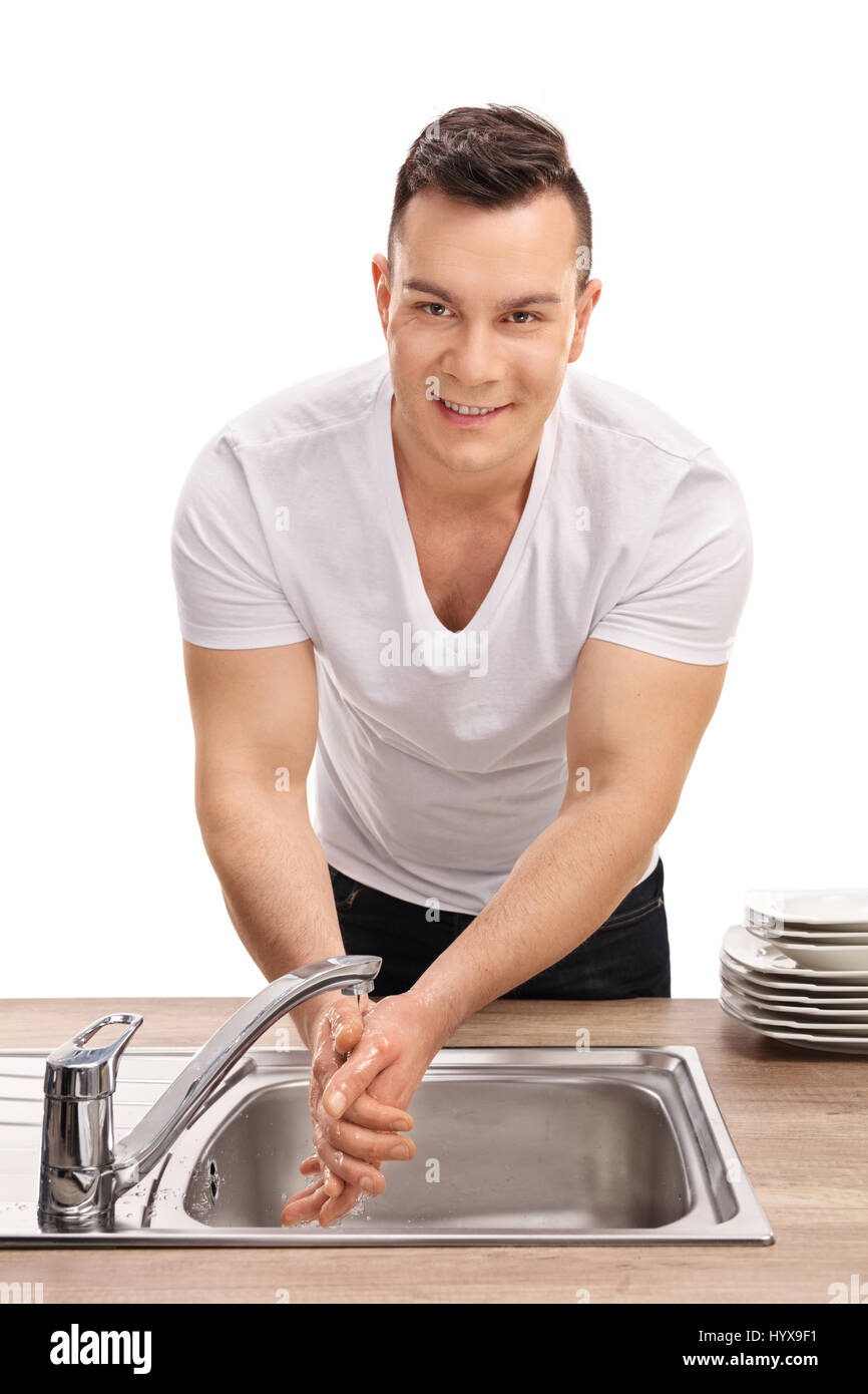 Young man washing his hands and looking at the camera isolated on white ...