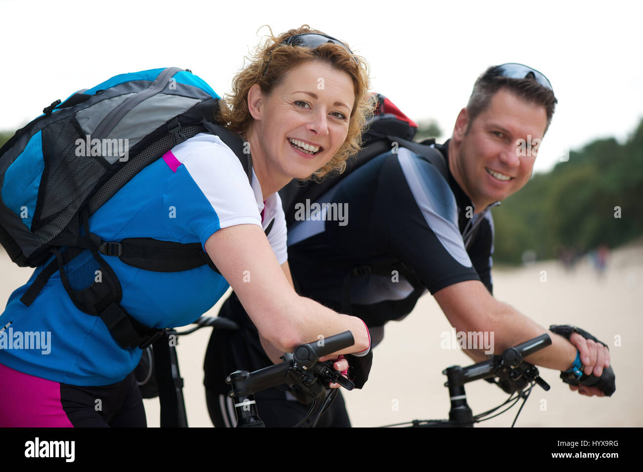 Portrait of a happy couple smiling with their bikes outdoors Stock ...