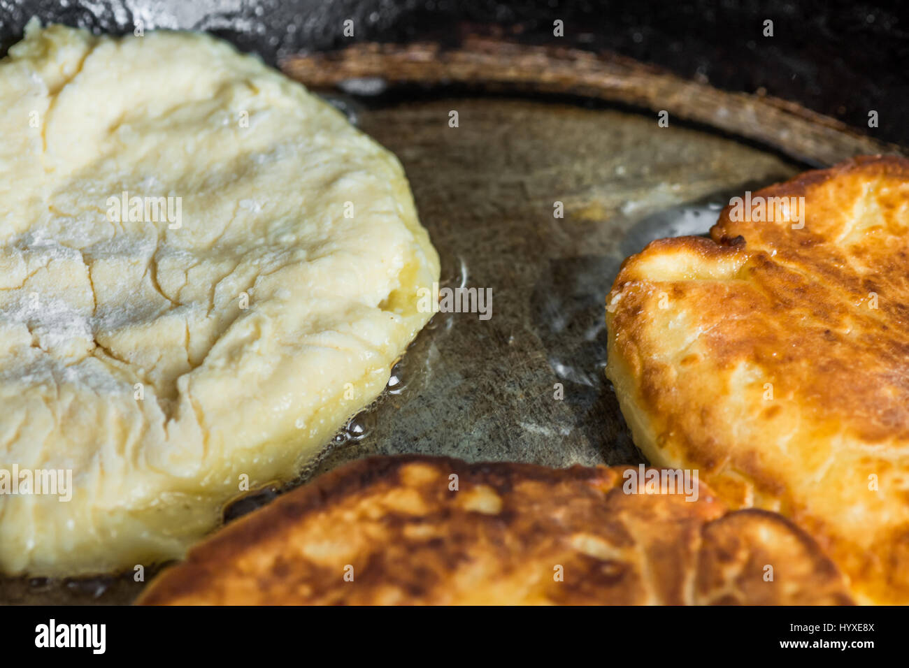 Process of frying cottage cheese fritters or pancakes in sizzling oil ...