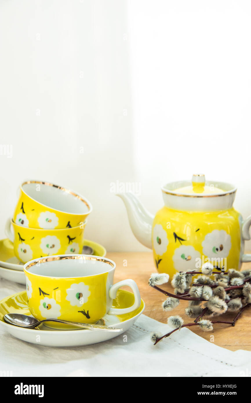 Elegant yellow tea set with floral ornament on aged wood table, bouquet ...