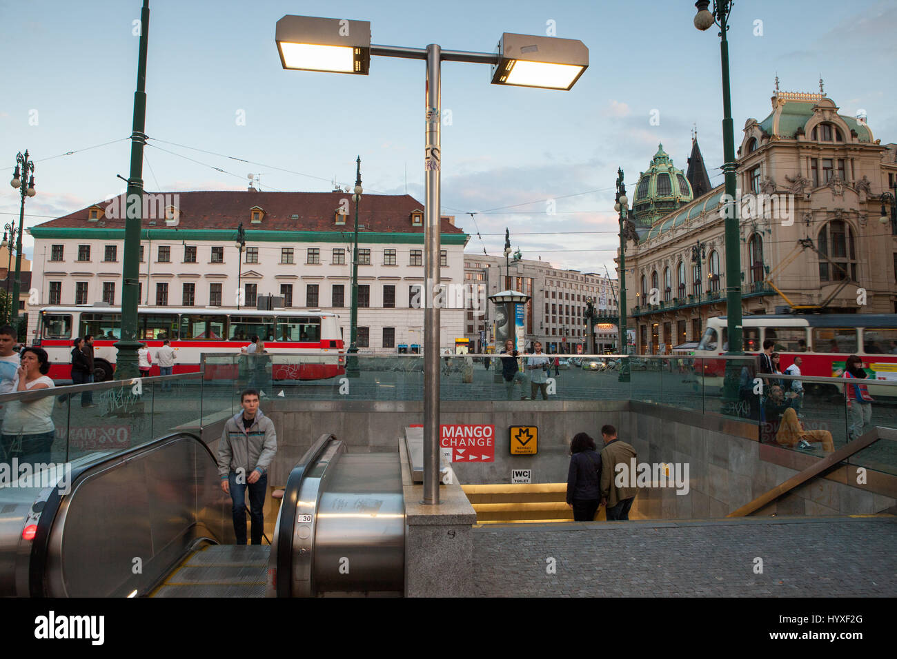 Pedestrians walk into a subway station as a bus and trolley ride ...