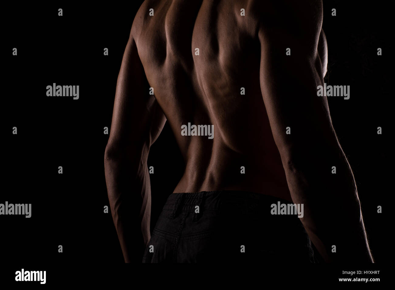Male fitness model, bodybuilder back pose on black background Stock ...