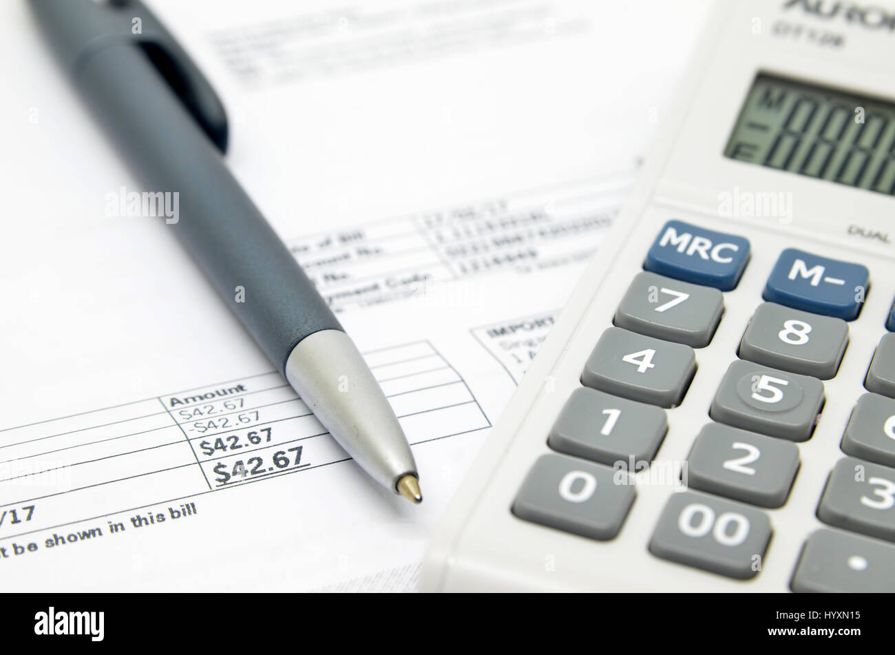 Pen on background of calculator and bill Stock Photo - Alamy
