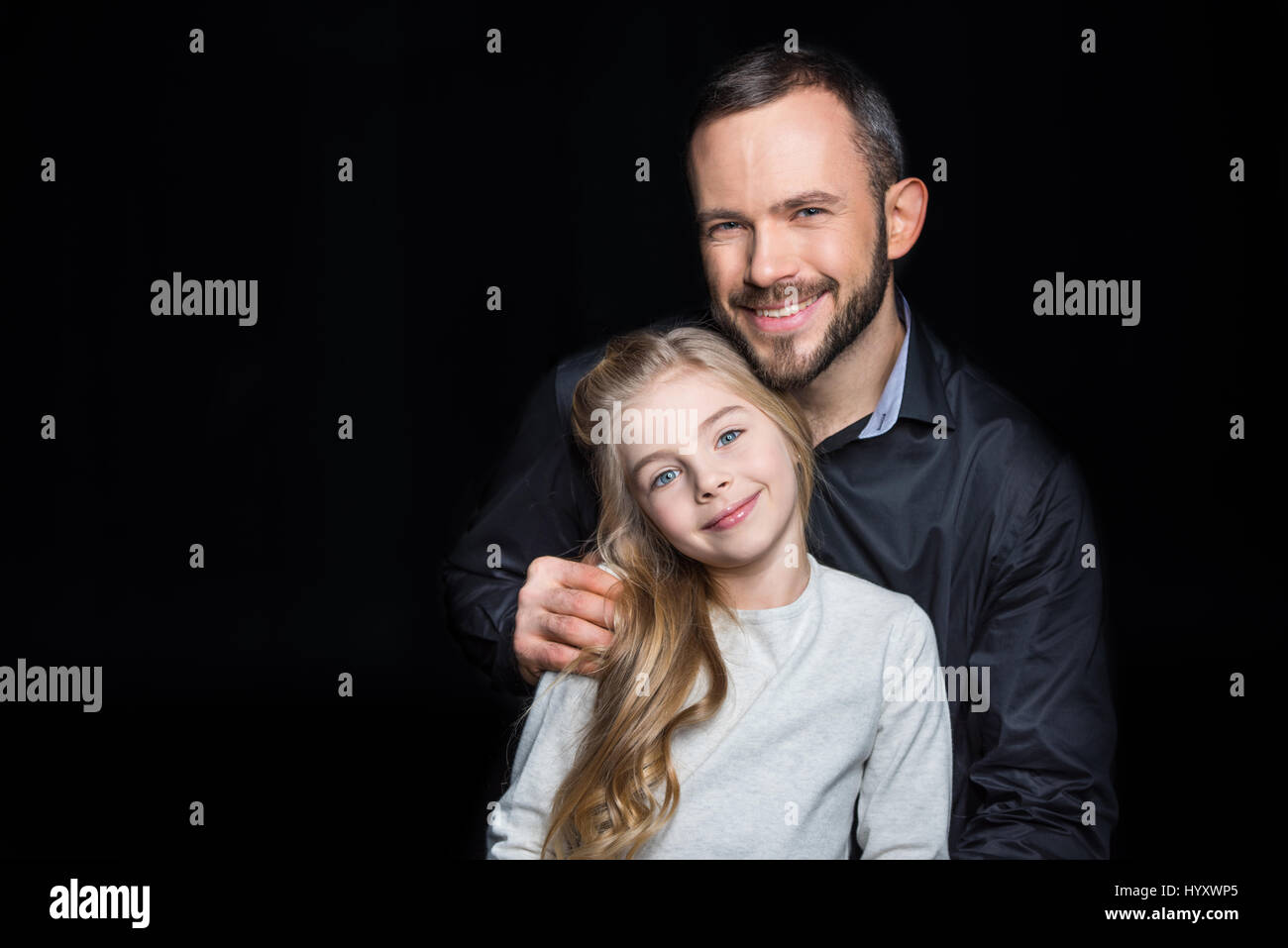 Portrait of smiling father and daughter standing together isolated on black Stock Photo - Alamy