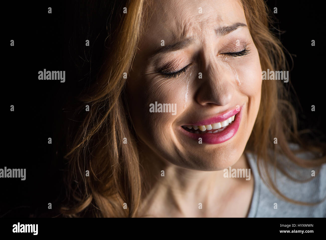 Close-up portrait of young beautiful woman crying on black Stock Photo ...