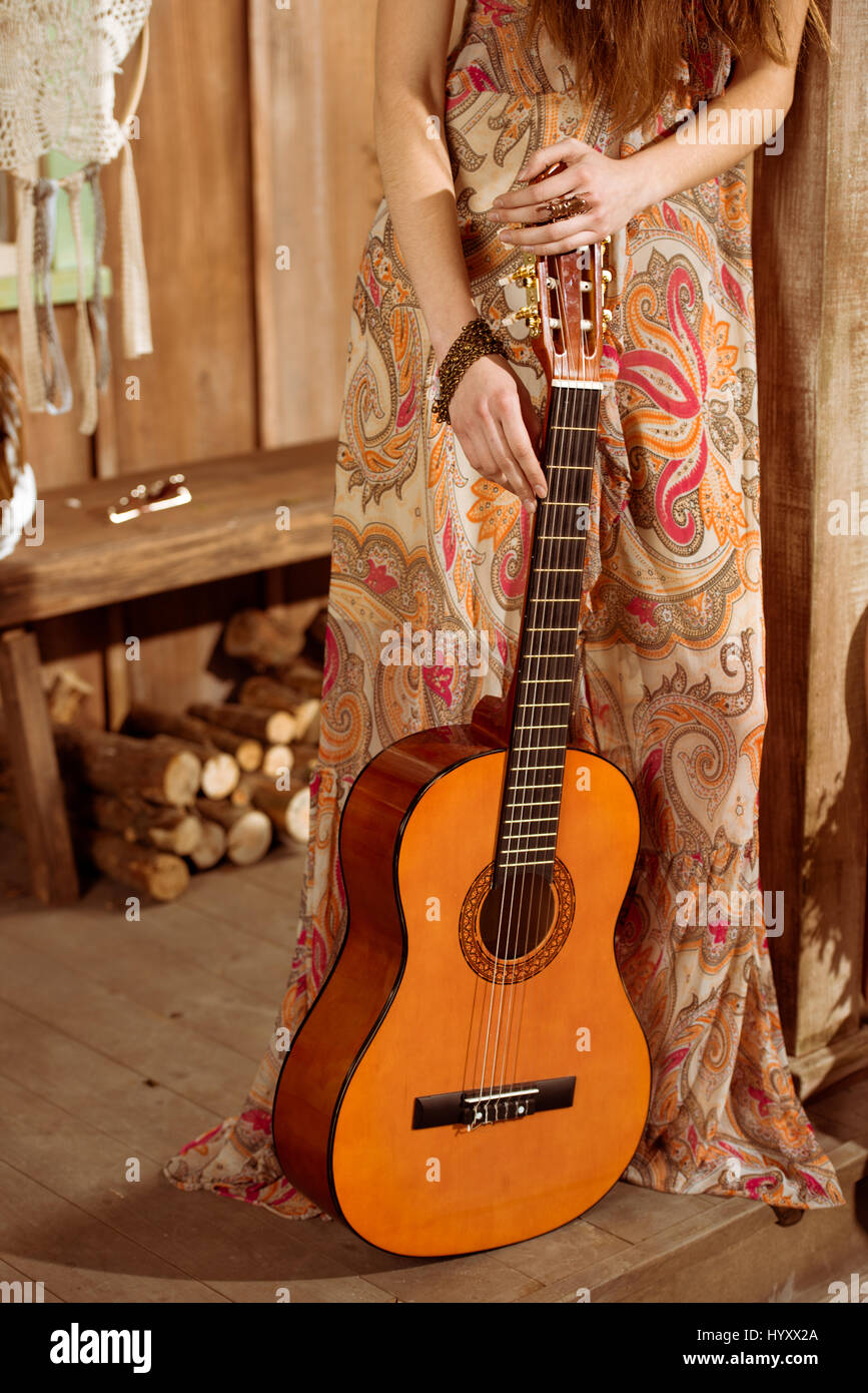 Partial view of young hippie woman in dress standing with guitar Stock ...