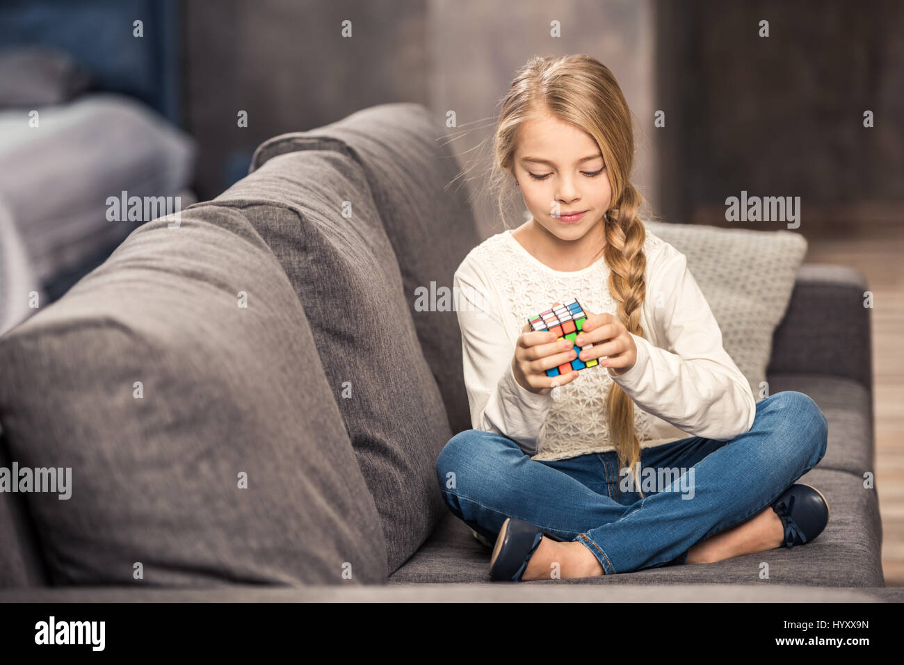 Cute little girl playing with cube Stock Photo - Alamy