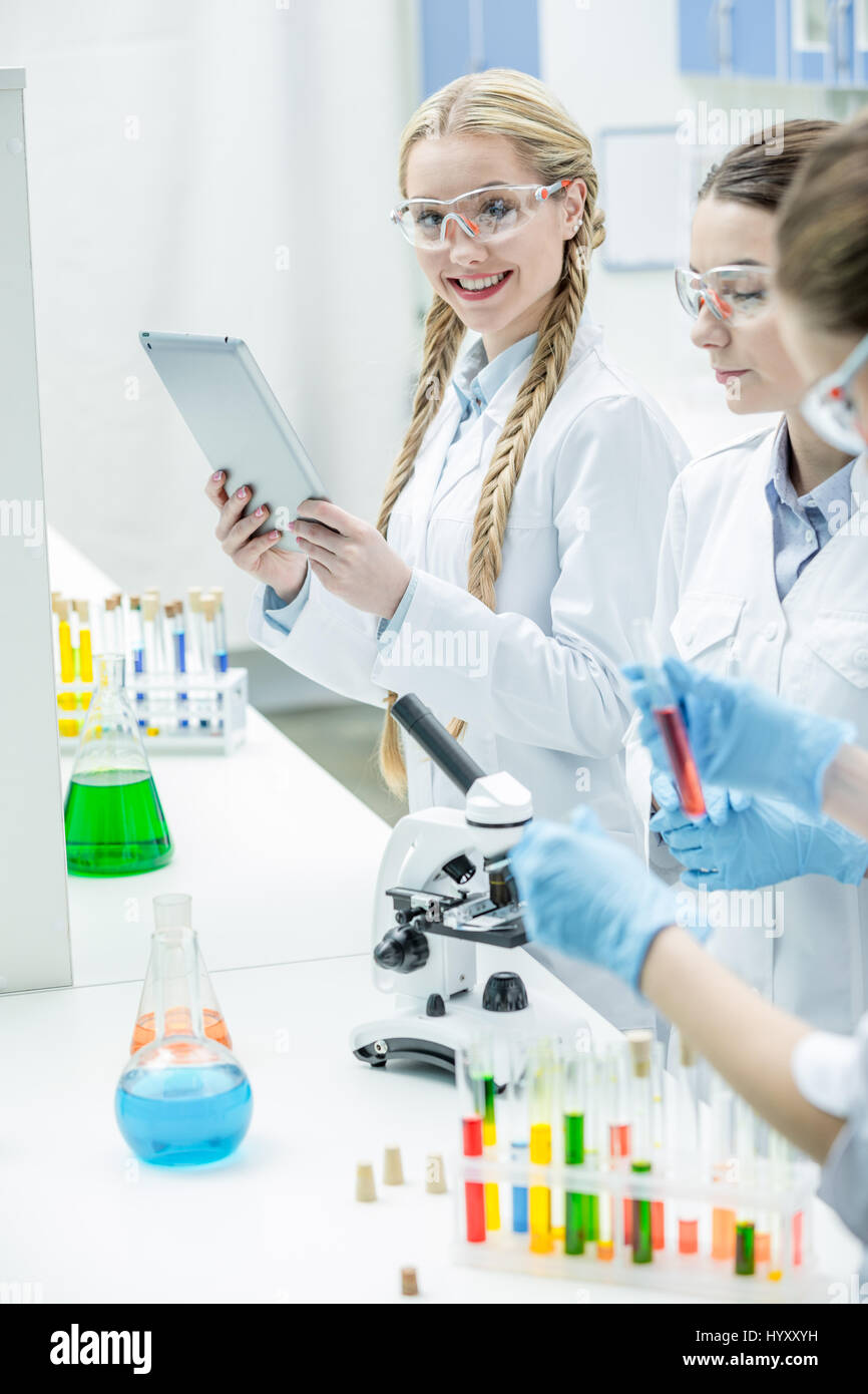 Young female scientists working with reagents in chemical laboratory ...