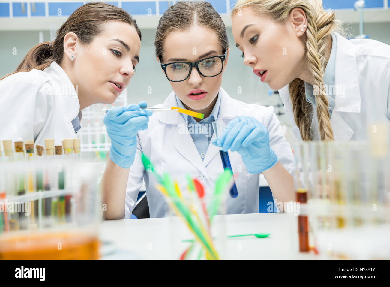 Three female scientists making experiment in chemical laboratory Stock ...