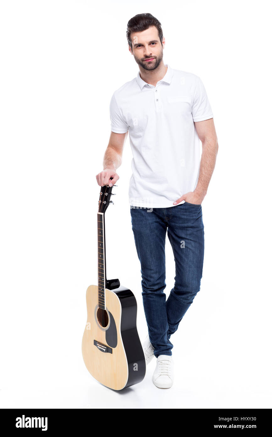 Full length portrait of handsome young man standing with guitar ...