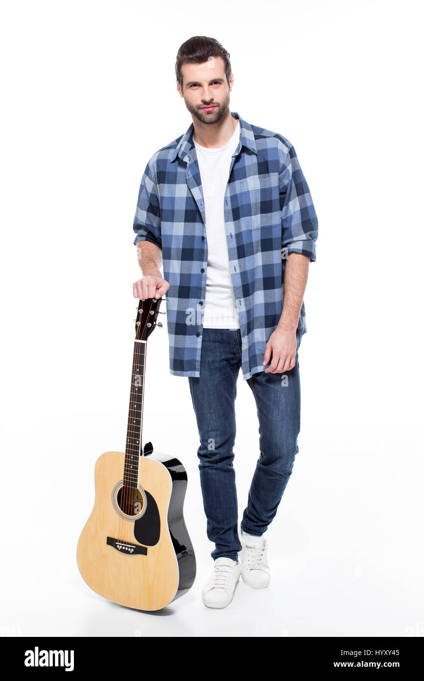 Full length portrait of handsome young man standing with guitar ...