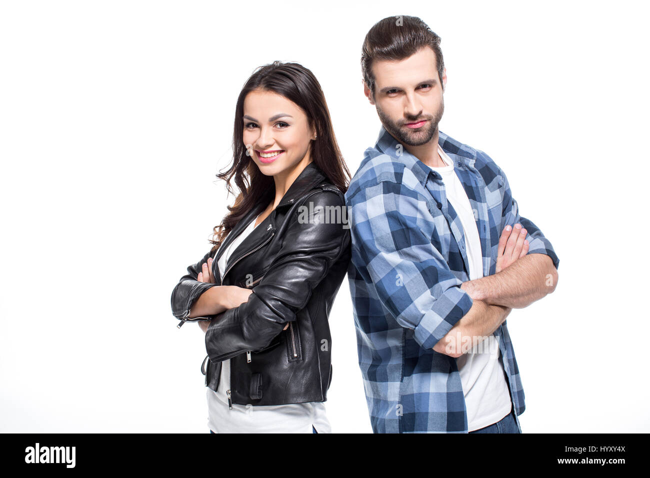 Beautiful young couple standing back to back with crossed arms isolated ...