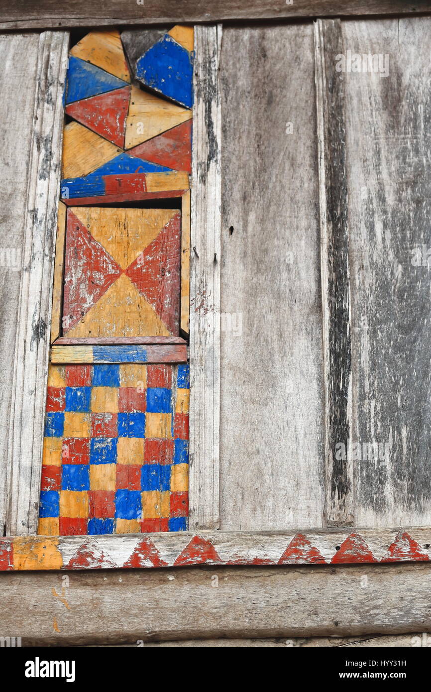 Colorfully yellow-red-blue painted wooden wall and paint-faded boards ...