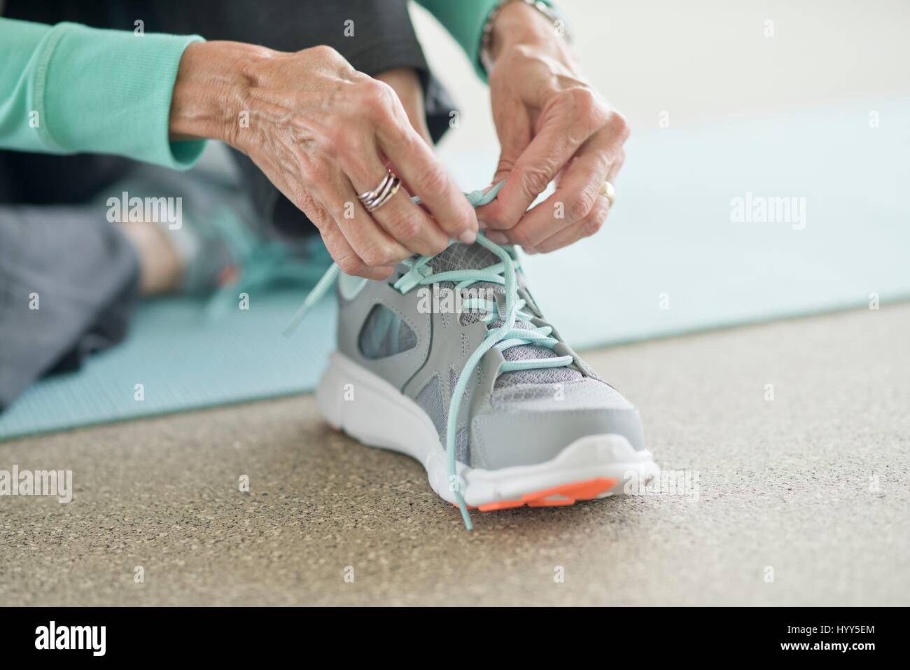 Senior woman lacing up trainers, close up Stock Photo - Alamy
