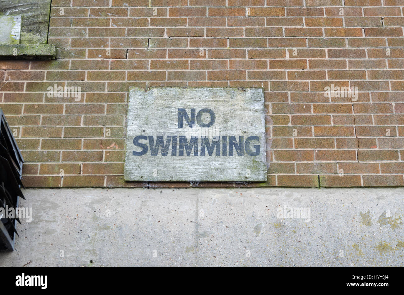 Old faded wooden sign saying no swimming Stock Photo - Alamy