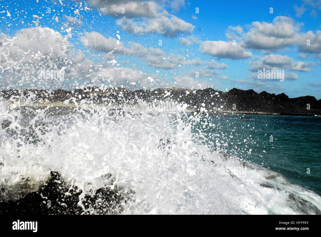 Water splash on the beach rocks and clouds Stock Photo - Alamy