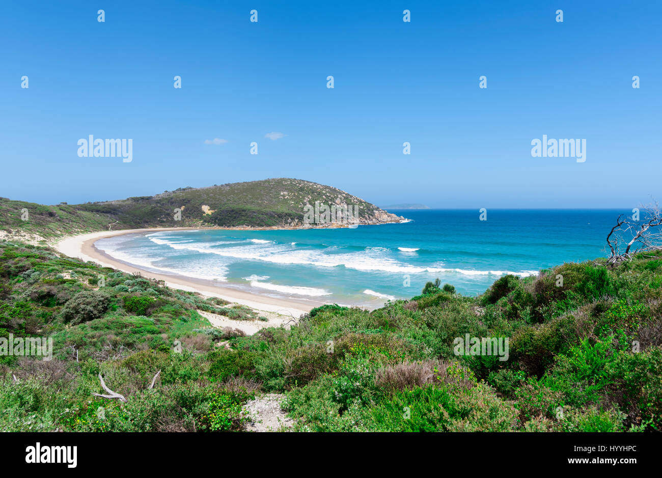 A beautiful view of a bright blue sea in the distance with white waves ...