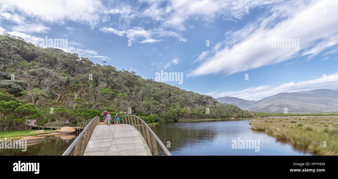 A beautiful landscape photo of a small bridge curving over a calmly ...