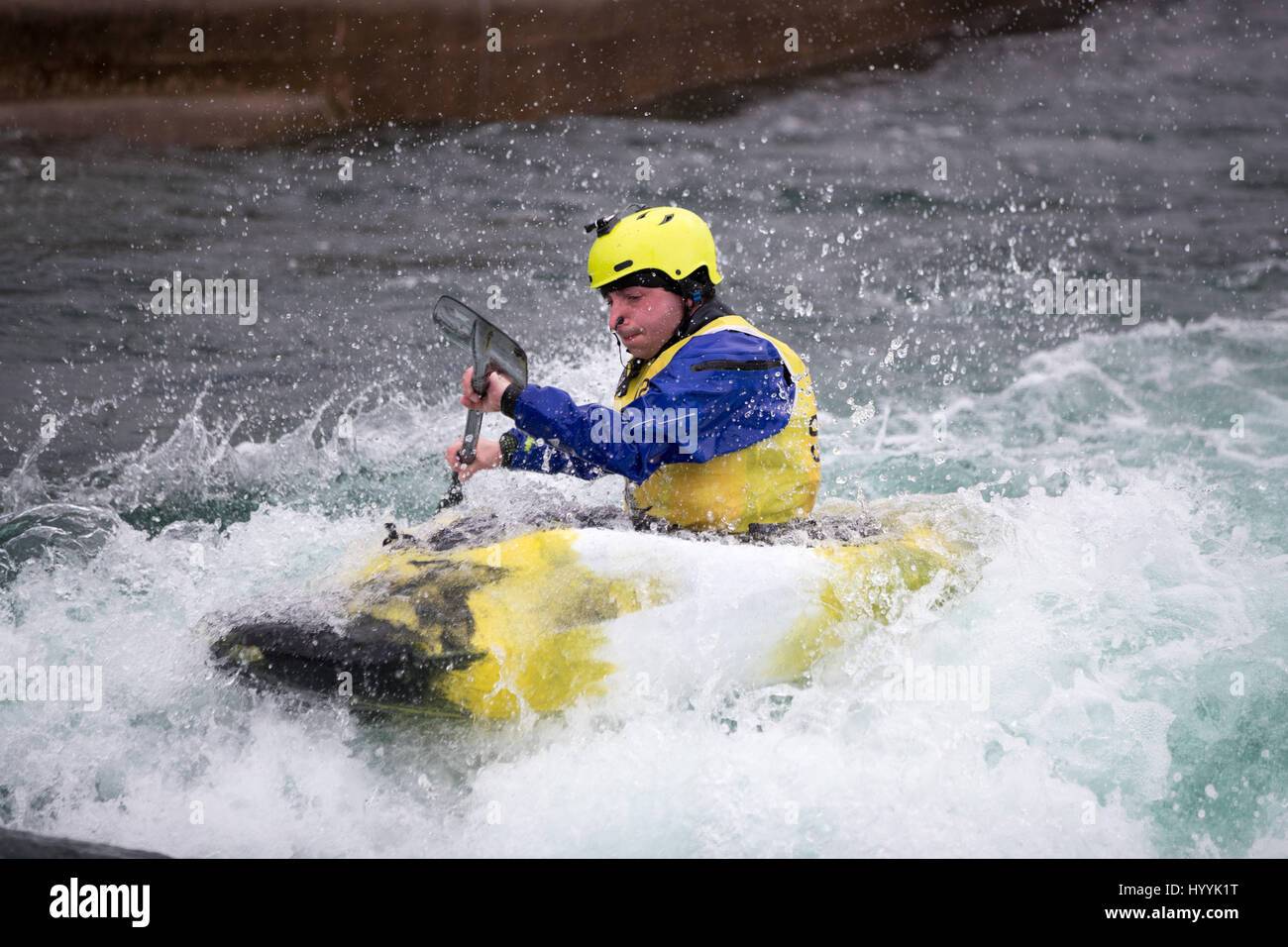 Man paddling hard in a kayak with water splashing all around Stock ...