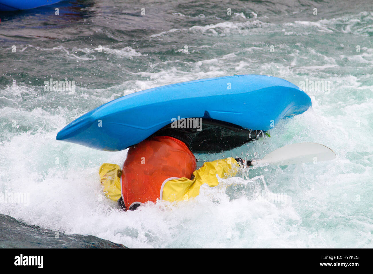 Man in kayak being capsized and over turned by the fast rushing water ...