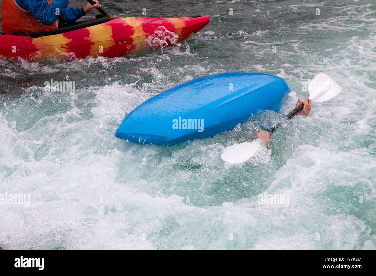 Over turned kayak boat in rough water showing two hands gripping onto ...