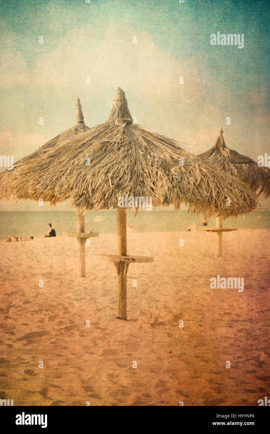 Vintage texture style view of tropical beach with grass hut palapas ...