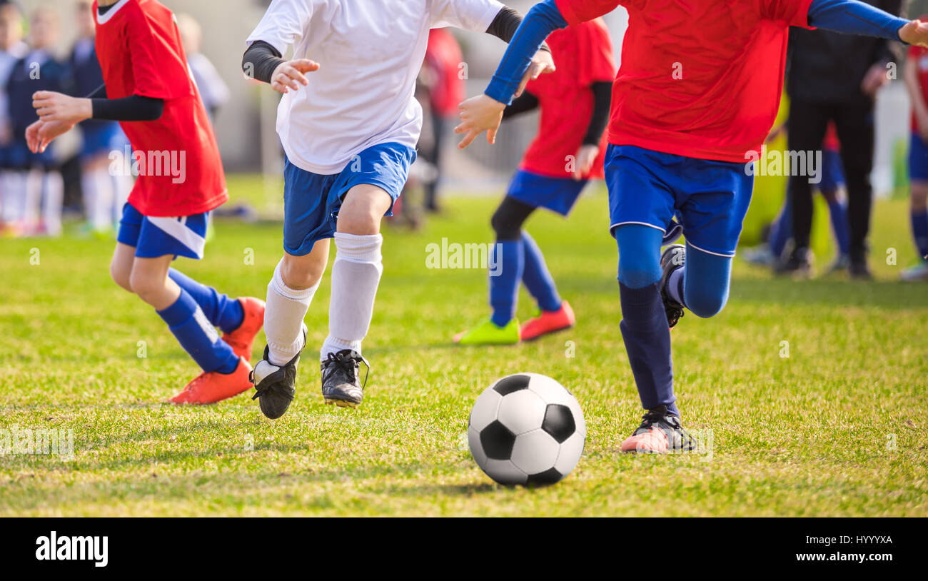 Junior Football Players Playing A Match. Footballers Kicking Football ...