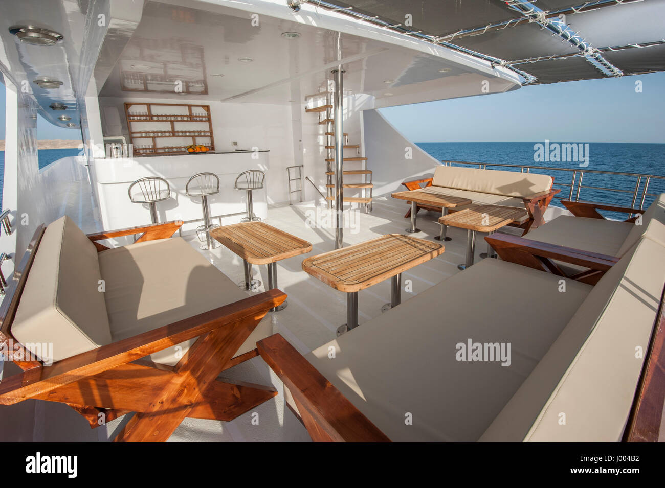 Rear sundeck of a large luxury motor yacht with chairs sofa table and ...