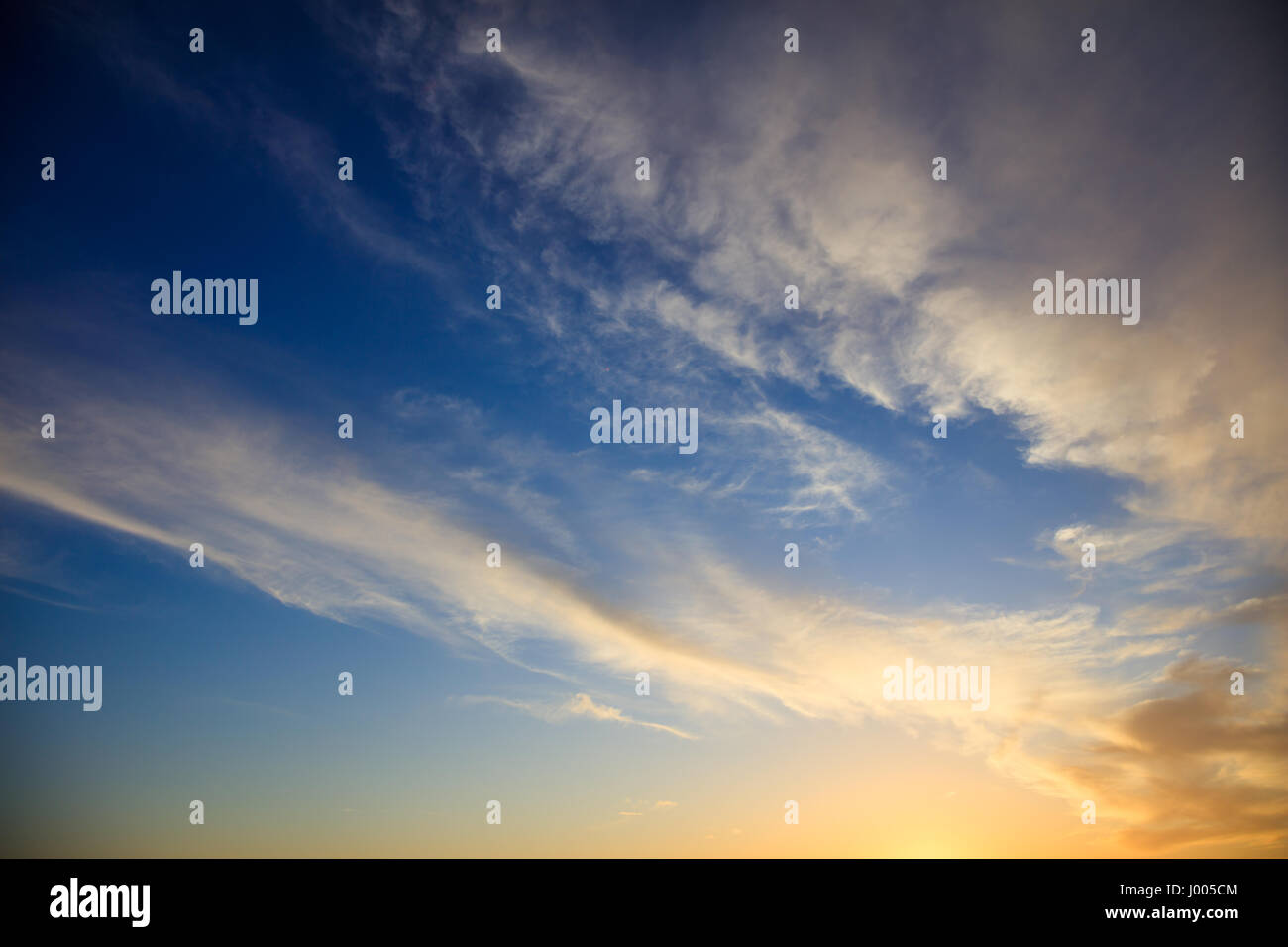 Blue sky with some clouds at sunset Stock Photo - Alamy