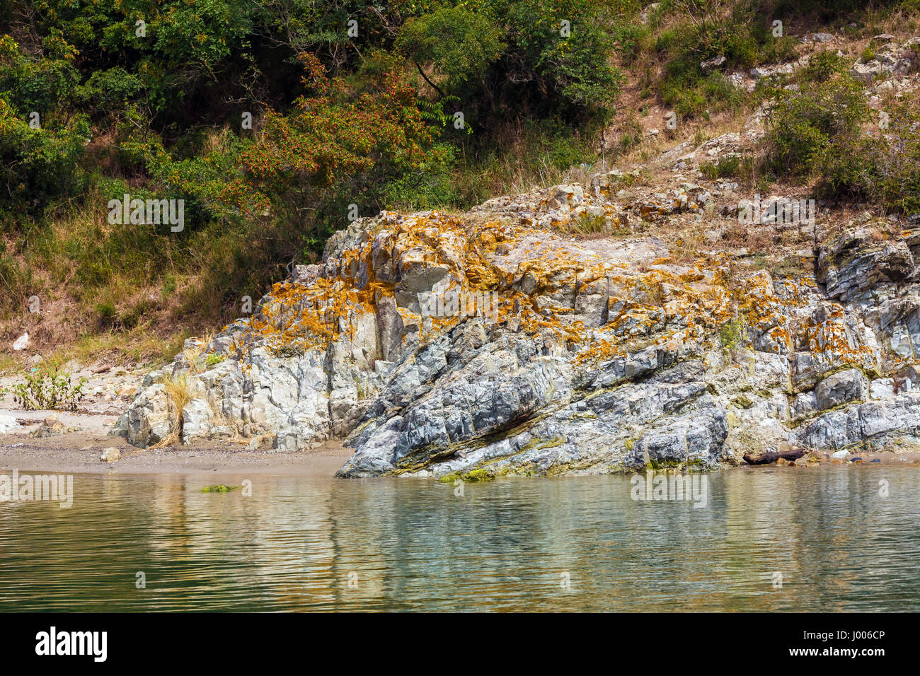 Rocky shore close-up. Stratified rocks in a cliff face. Rocky mountains ...