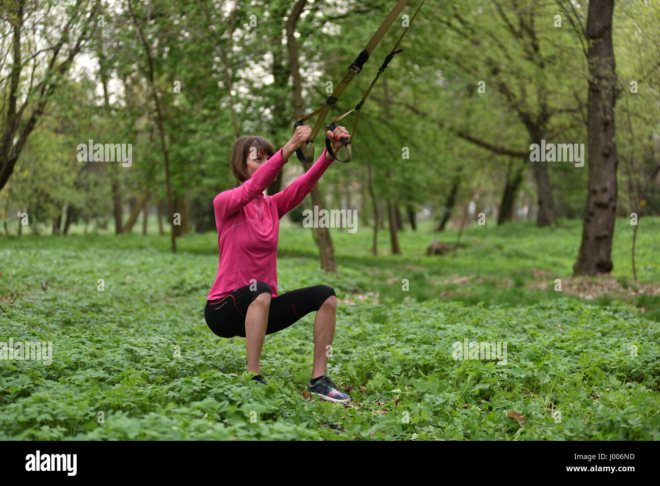 Beautiful young woman doing TRX exercise with suspension trainer sling ...