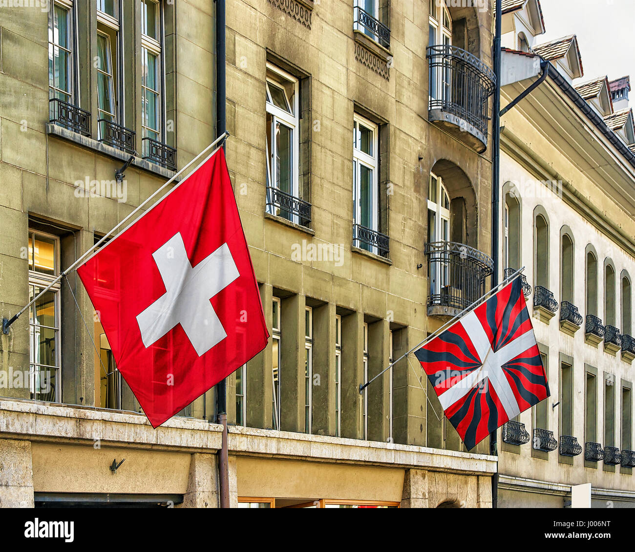 Swiss Flags waving in the street in the old city center of Bern ...