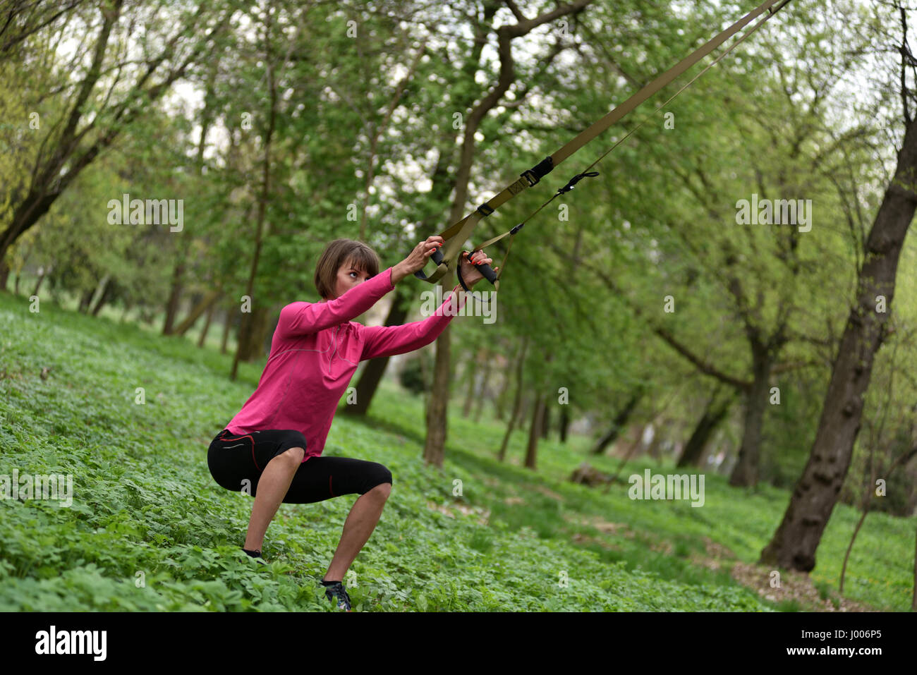 Beautiful young woman doing TRX exercise with suspension trainer sling ...