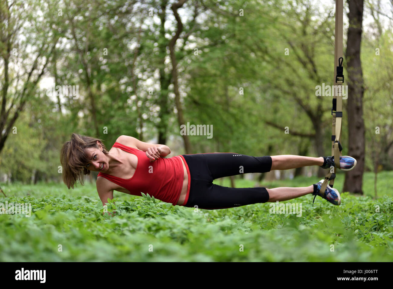 Beautiful young woman doing TRX exercise with suspension trainer sling ...