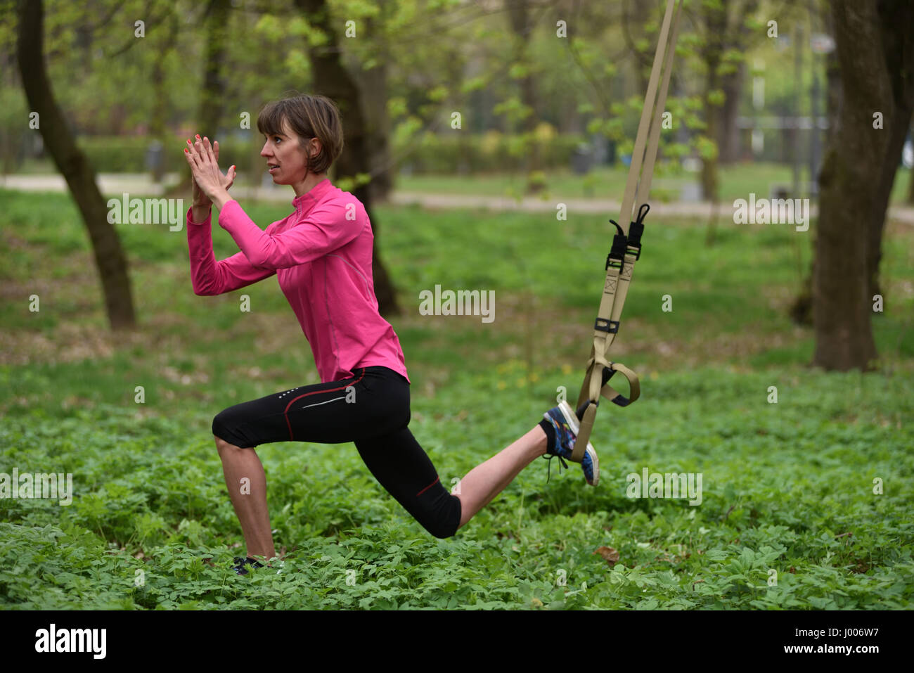 Beautiful young woman doing TRX exercise with suspension trainer sling ...