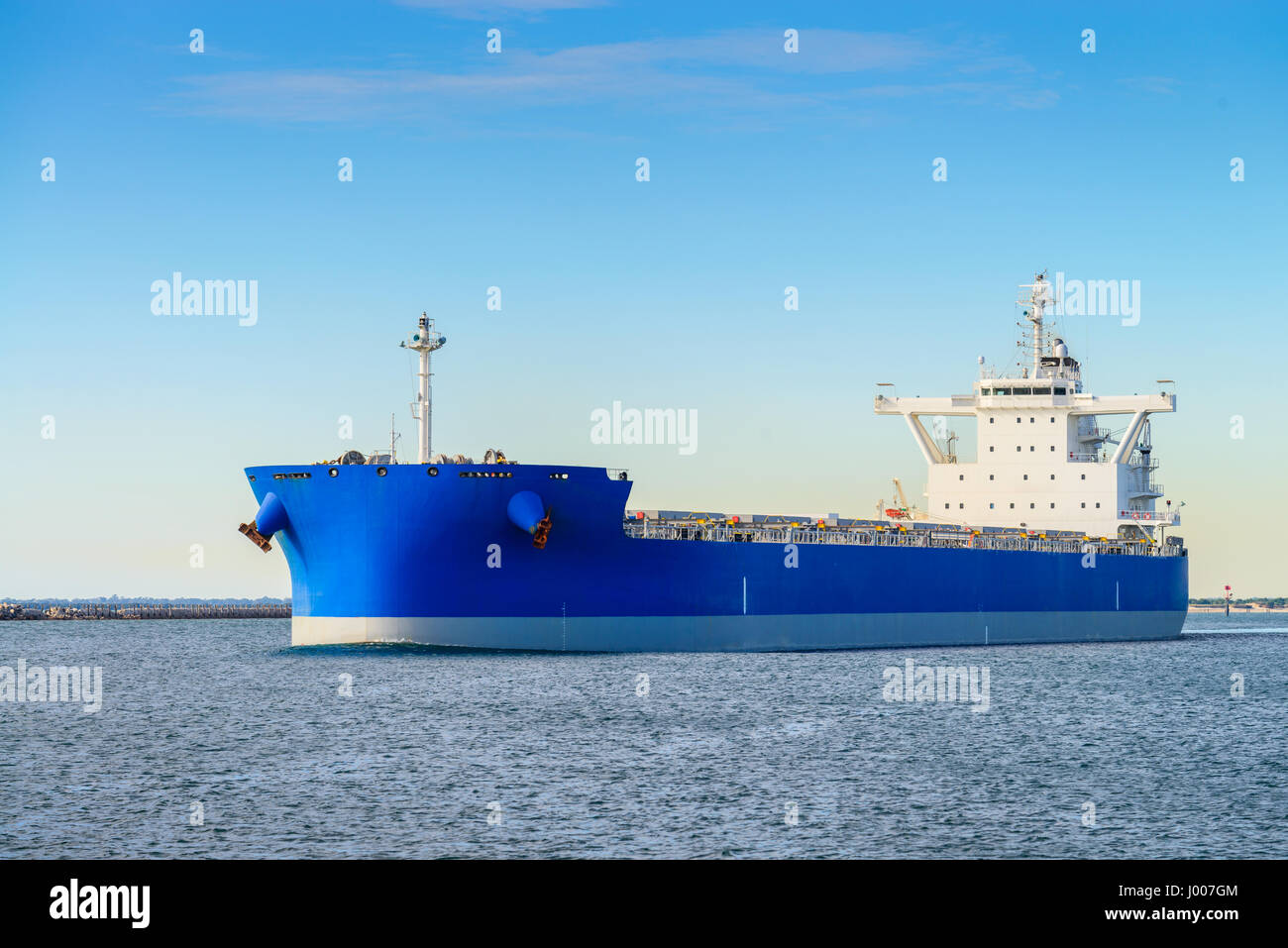 Cargo ship heading to open sea through port canal Stock Photo - Alamy