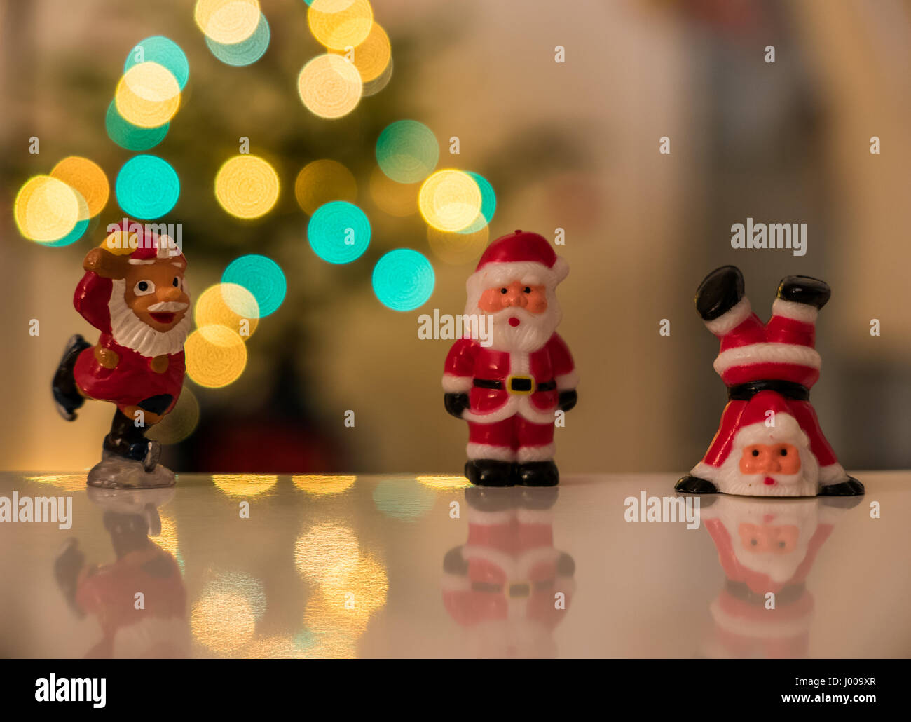 Fun Father Christmas figurines on white surface with Christmas lights ...