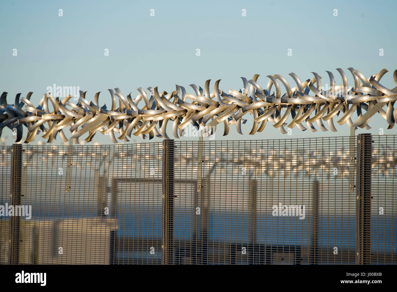 Barbed wire security fence at a secure compound site at sunset Stock ...