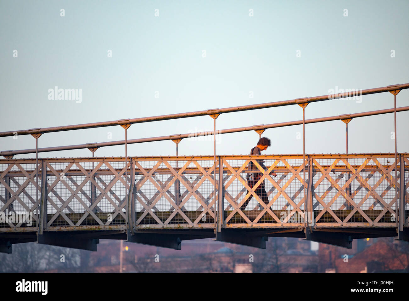 A person crossing over the River Dee Suspension Bridge that crosses ...